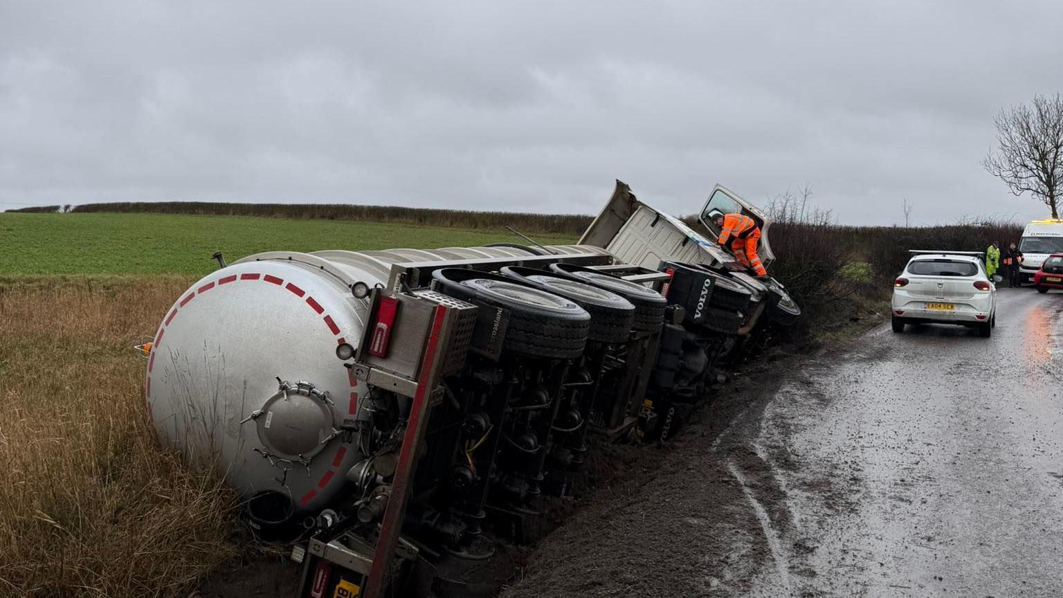 HGV tanker ends up on its side on country road
