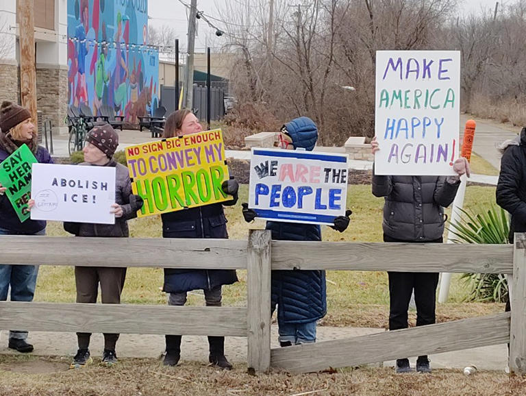 Anti-ICE protesters line 86th Street with signs