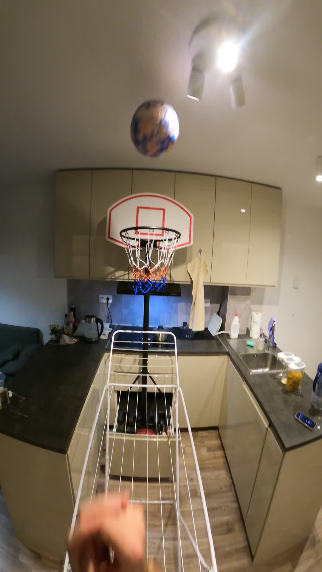 Shooting hoops with a basketball in the kitchen