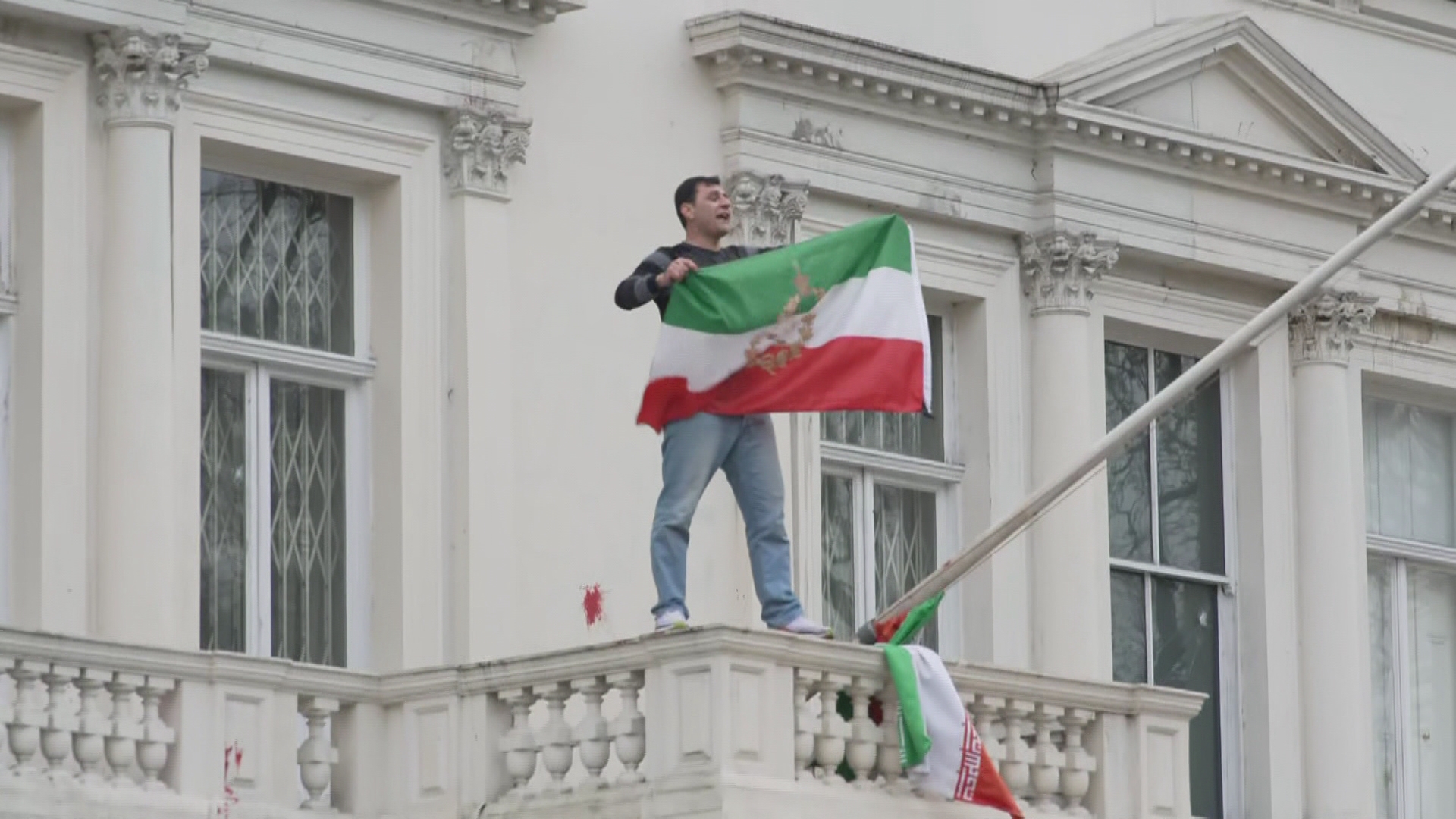 Protester swaps out Iran's flag on top of London embassy