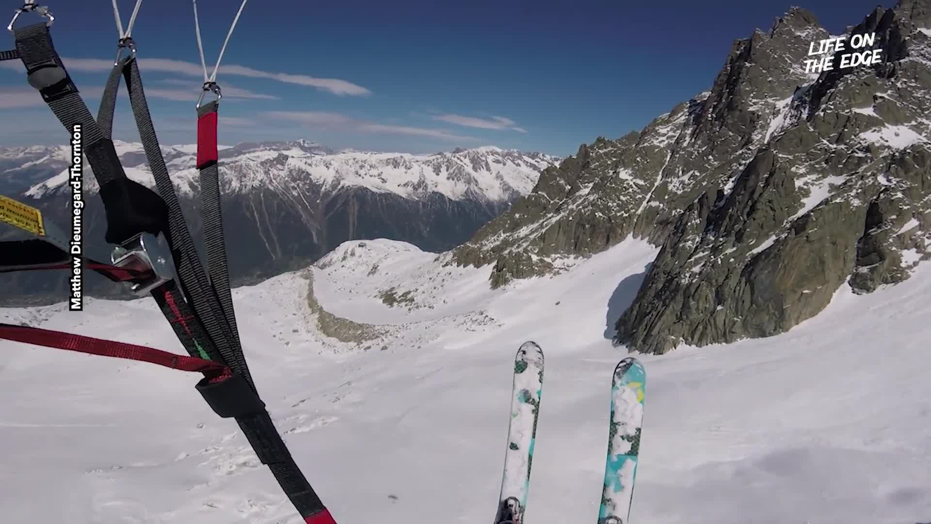 Skier paraglides off a cliff