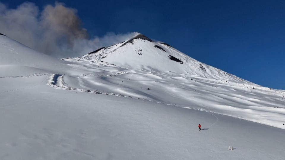 Skier rides down Mt. Etna as it erupts