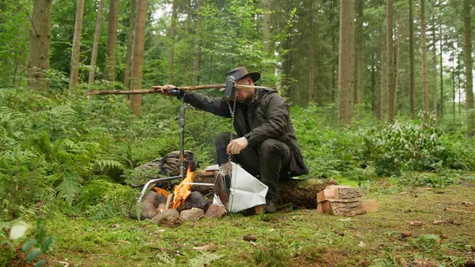 Grilling a whole dolphinfish in a forest over open fire