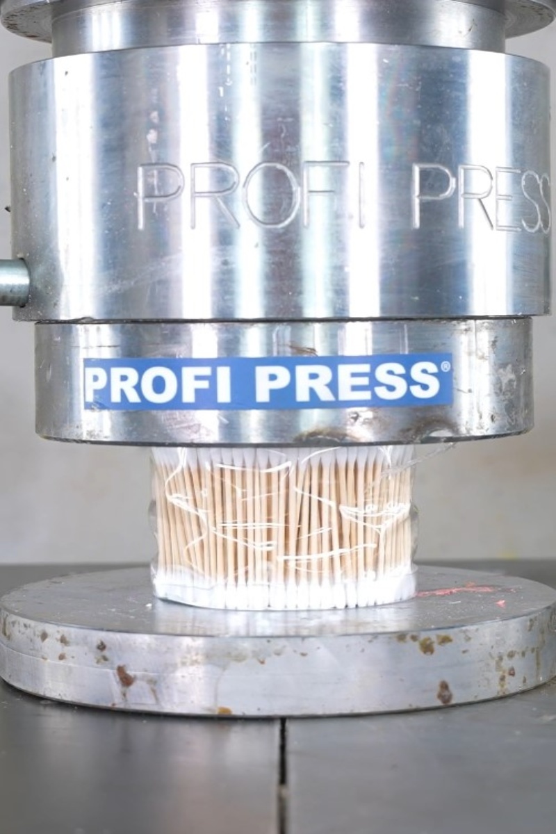 Zgniatanie całej paczki wykałaczek pod prasą hydrauliczną