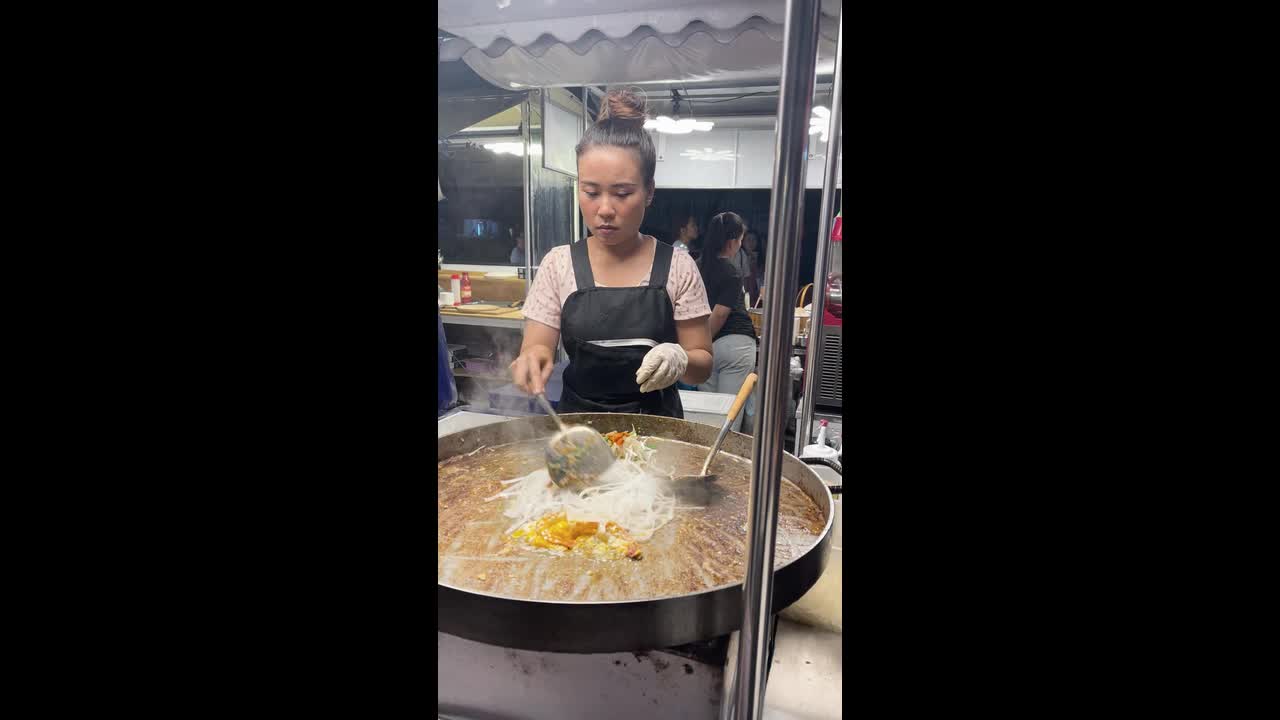 Street food chef rustles up delicious serving of pad thai noodles