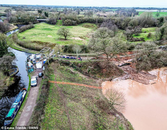 Workers attempt to rescue three narrowboats dragged to the depths by ...