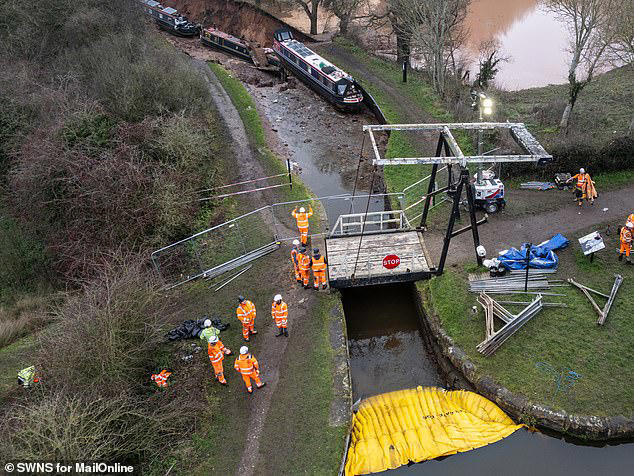 Workers attempt to rescue three narrowboats dragged to the depths by ...