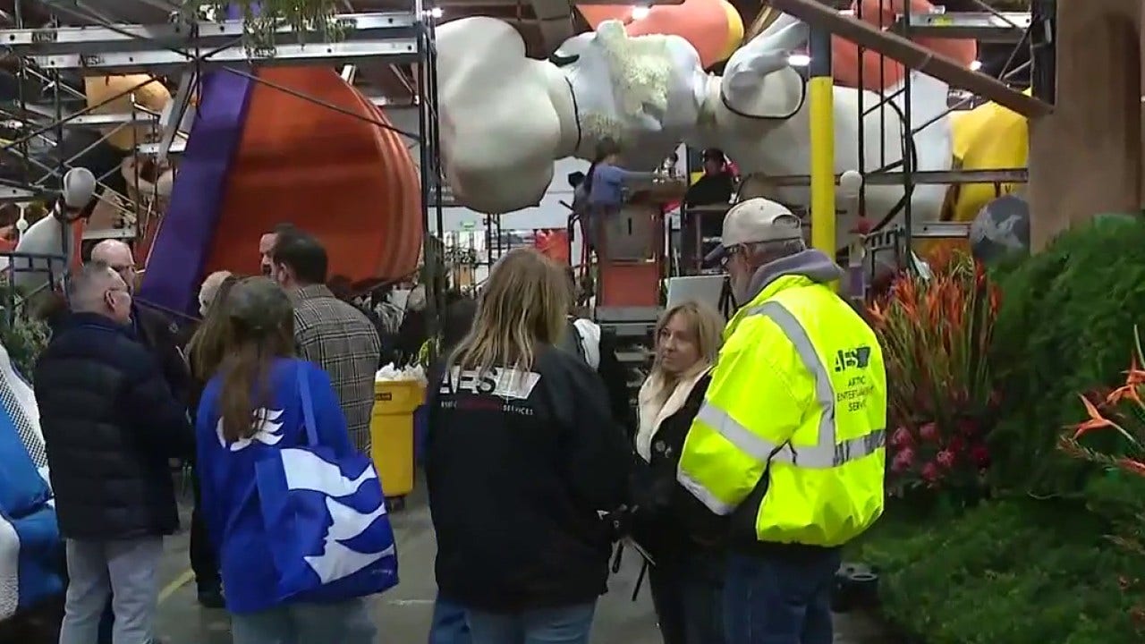 Volunteers working to get floats down the Rose Parade route, rain or shine
