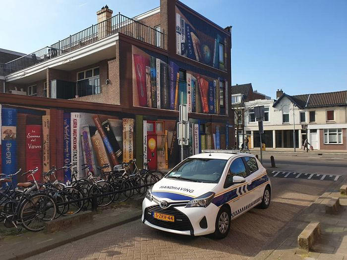 Dutch artists paint giant bookcase on an apartment building featuring ...