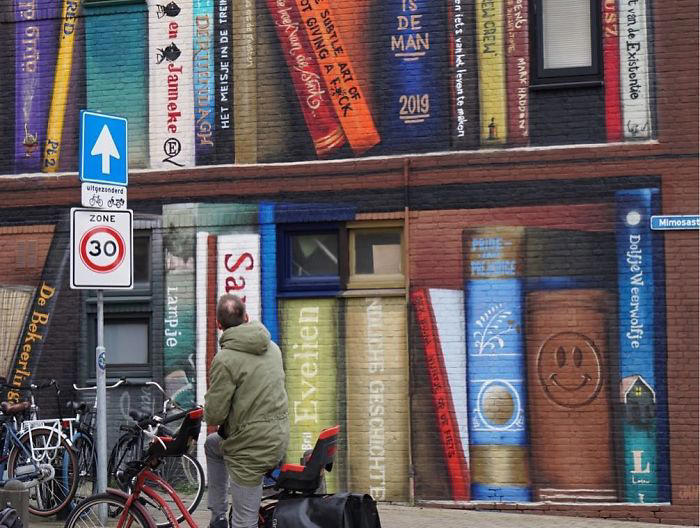 Dutch artists paint giant bookcase on an apartment building featuring ...