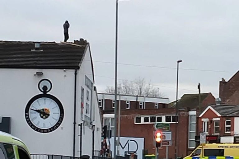 Man on roof of town hall comes down after 14 hours