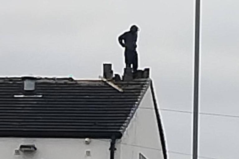 Man on roof of town hall comes down after 14 hours