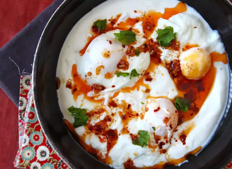 Turkish-style eggs on a yogurt base with spicy oil - çilbir