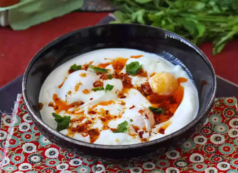 Turkish-style eggs on a yogurt base with spicy oil - çilbir