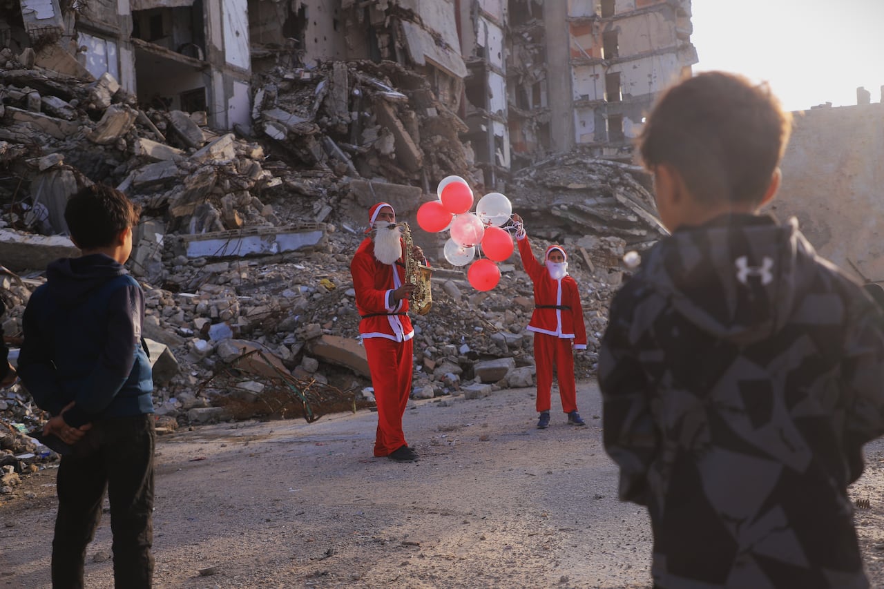 Father and son dress as Santa, visit Gaza tent city with gifts, music ...