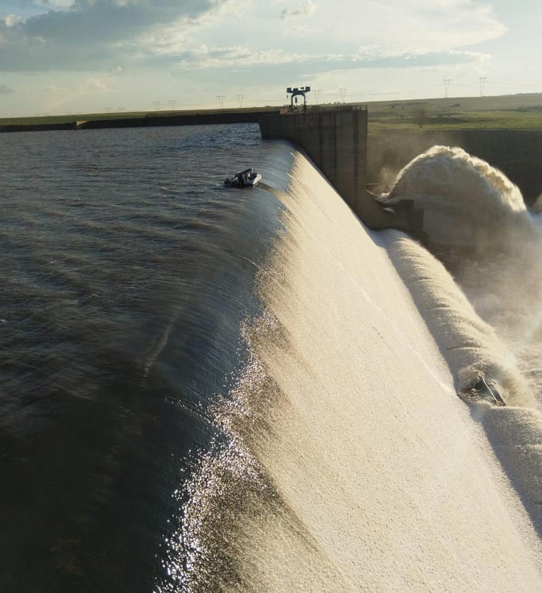 Rescue drama as men cling to boat on 130ft dam edge