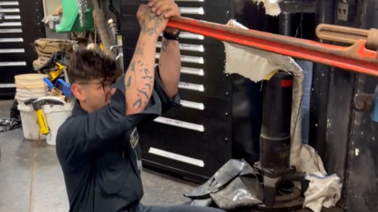 Worker hilariously wraps himself around a wrench to loosen a seized bolt