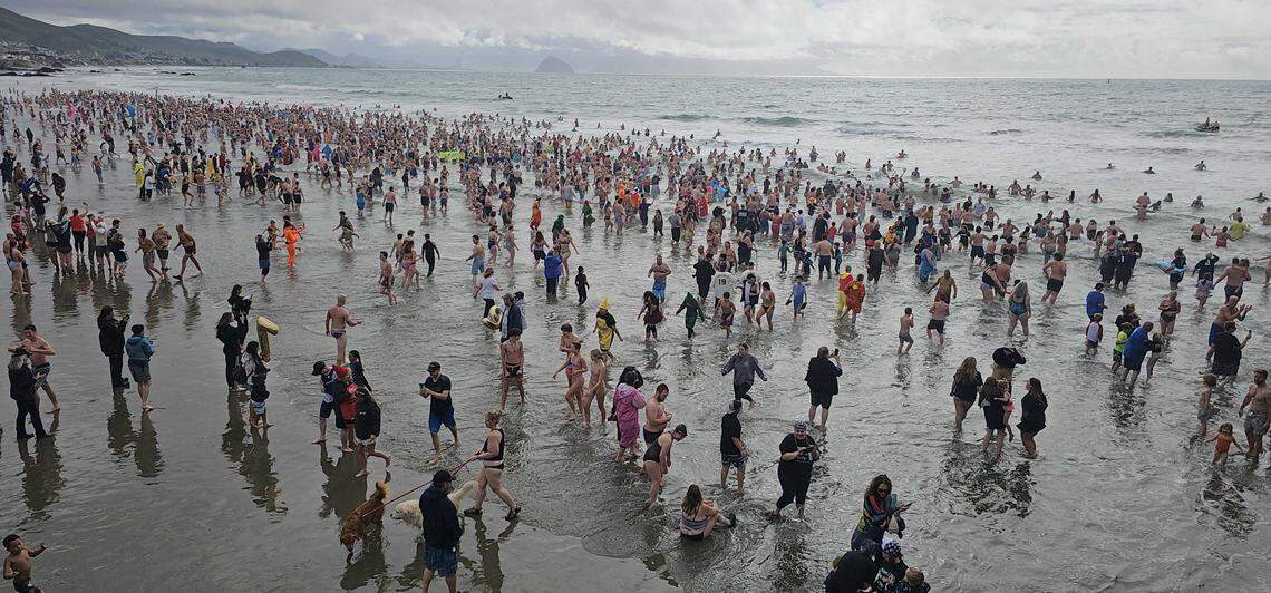 Thousands brave frigid SLO County polar bear dip - despite New Year's rain