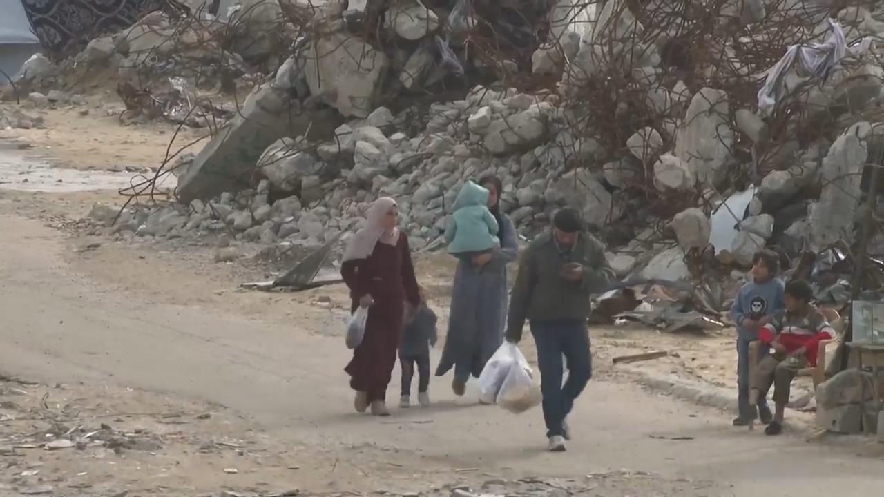 Palestinians walk through rubble of Gaza City to bring back aid on ...