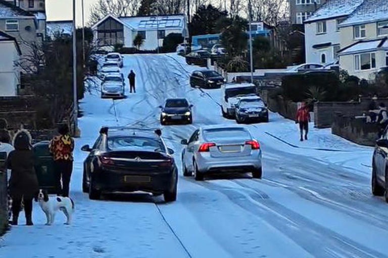Dramatic video shows VW slide down snow covered street as people dive ...