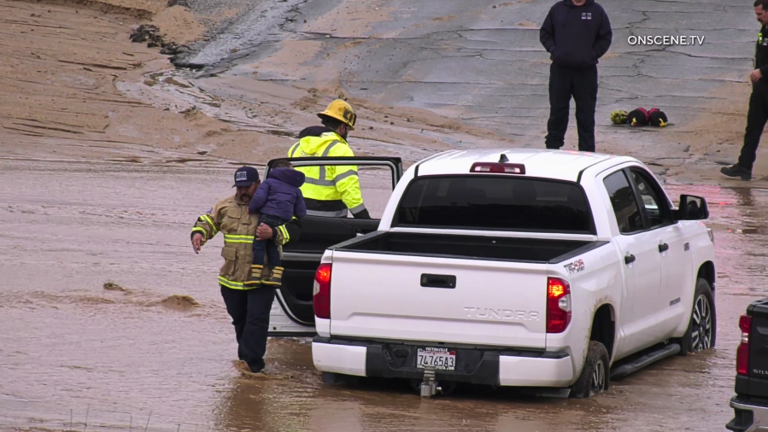 Child carried to safety after vehicles stuck in Southern California ...