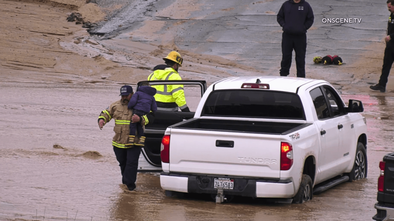 Child carried to safety after vehicles stuck in Southern California ...