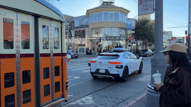 Tourists pose with Waymo blocking trolley in San Francisco