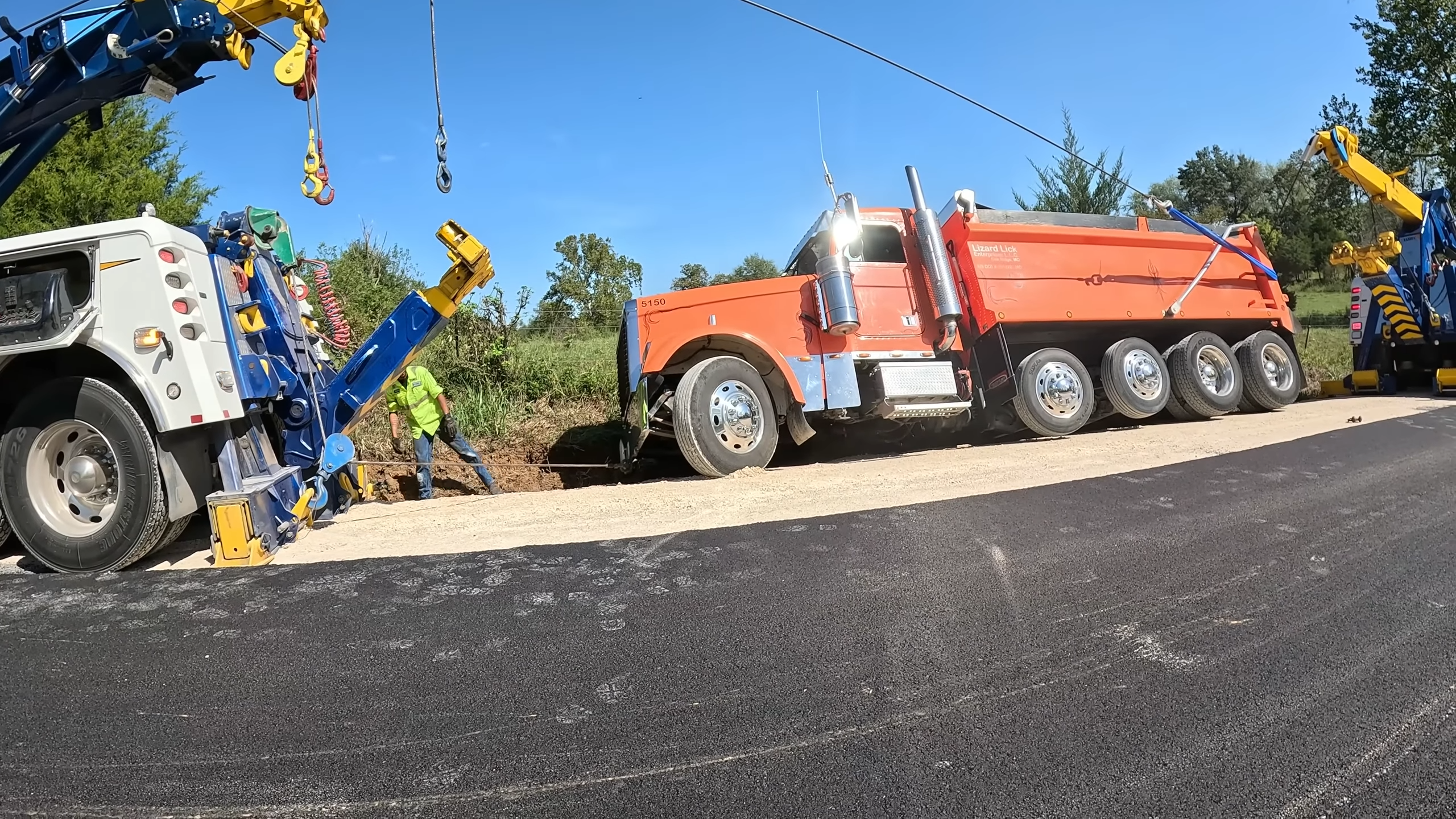 Dump truck with hot asphalt slides off gravel shoulder