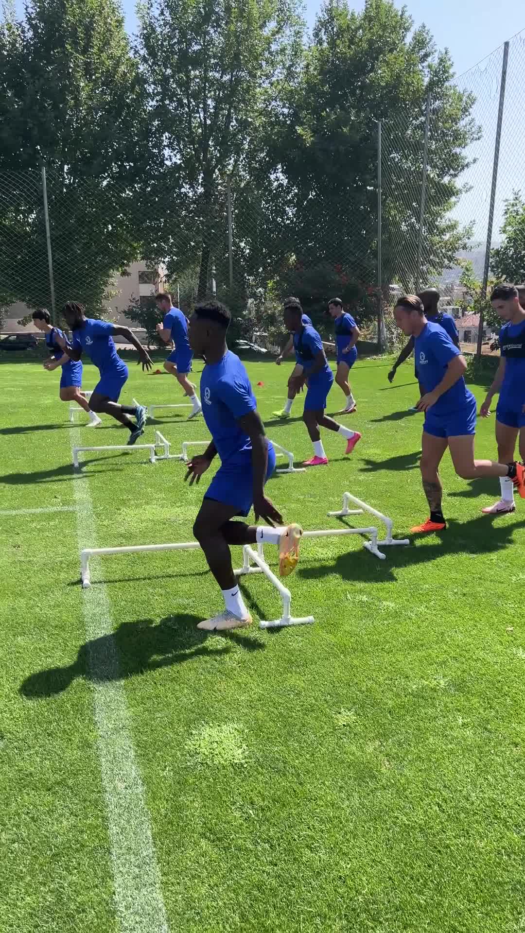 Intense team training session with hurdle drills