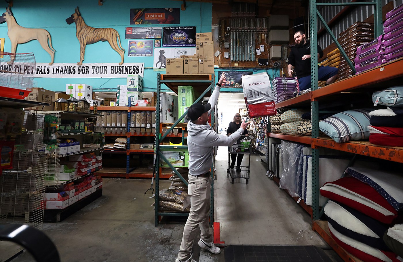 Photo | Employees at Pet Pals in Soquel toss bag of dog food