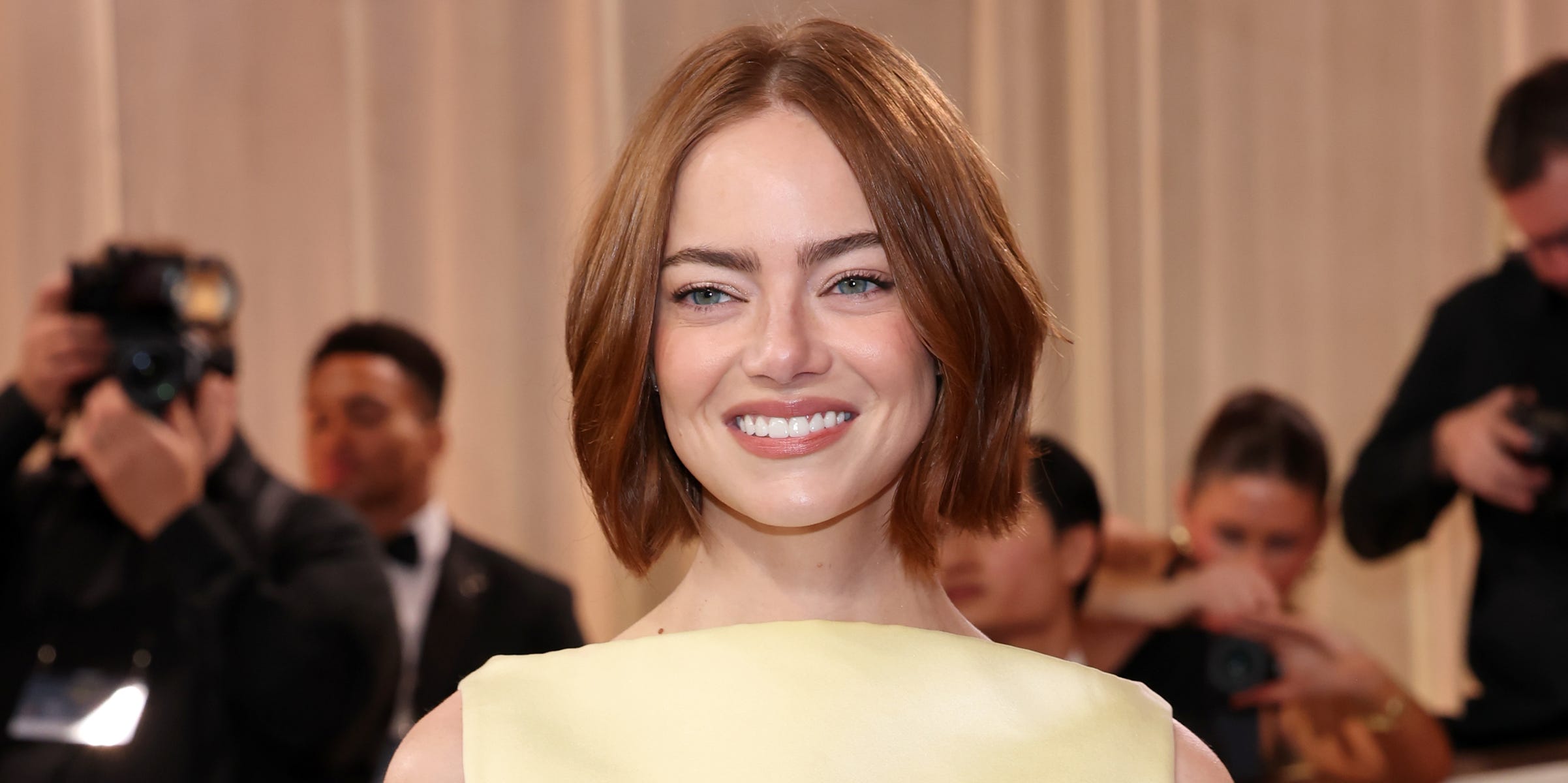 Emma Stone shows off her toned abs in a butter yellow crop top and ...