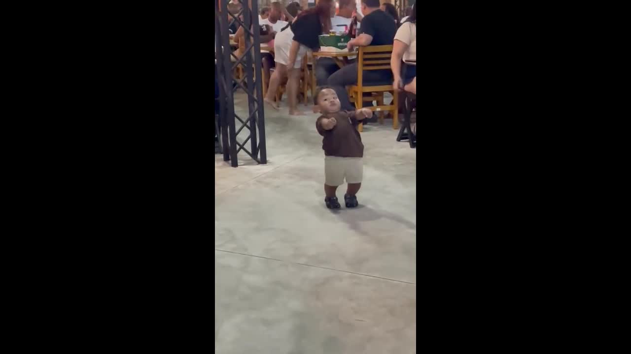 Young boy dances and drums in restaurant in Brazil