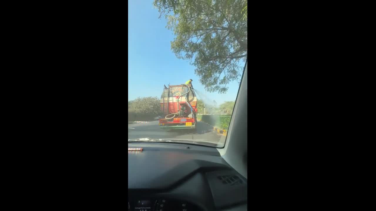 Driver turns roadside watering into an impromptu car wash in Gurgaon, India