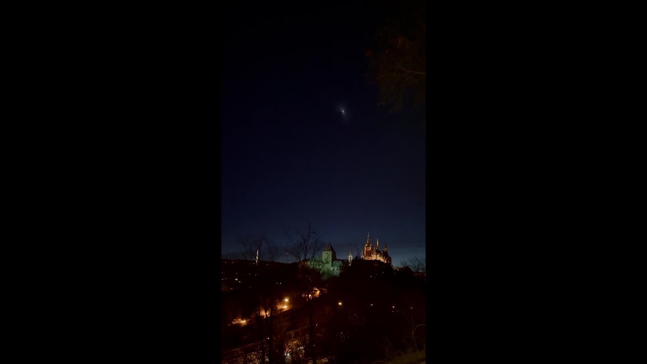 SpaceX Falcon 9 rocket illuminates night sky over Prague Castle
