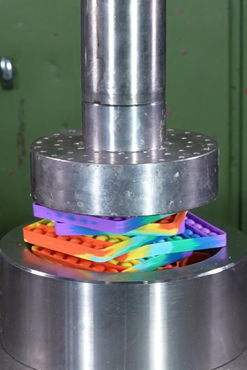 Rainbow pop it fidgets getting crushed under hydraulic press