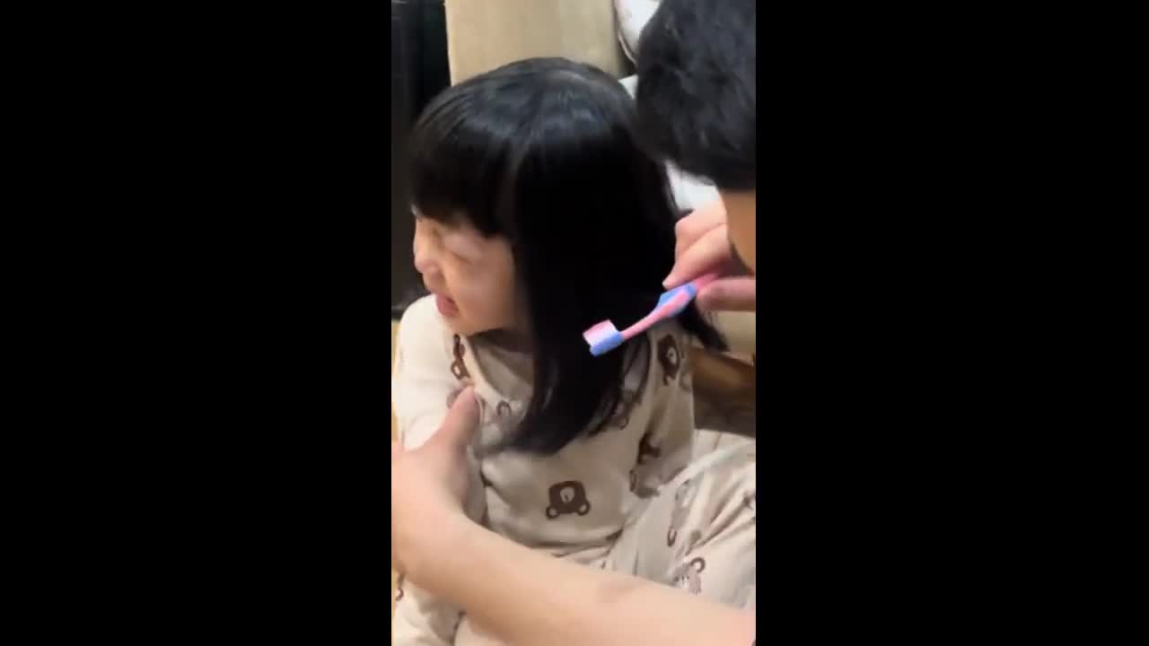 Daughter lets dog brush her teeth in Batam, Indonesia