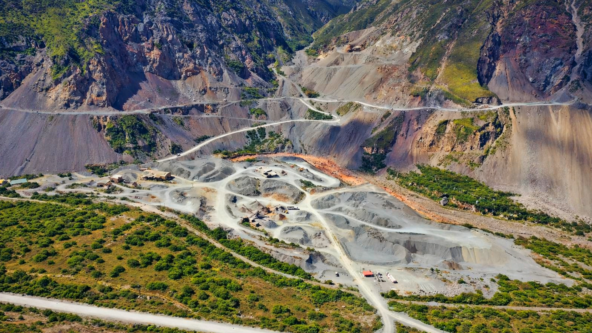 An industrial excavation site in a mountain valley
