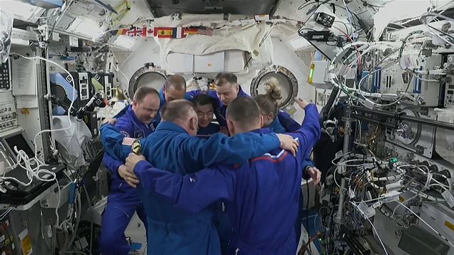 Astronauts onboard ISS perform group hug after ceremonial key is passed ...