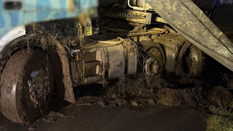 Road closed after lorry overturns into ditch