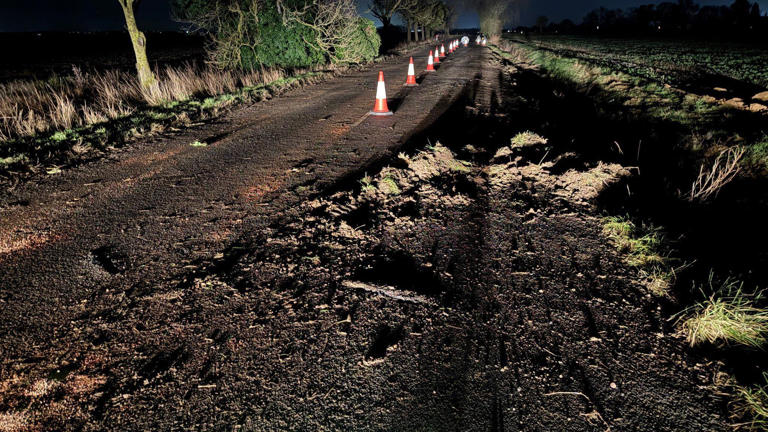 Road closed after lorry overturns into ditch