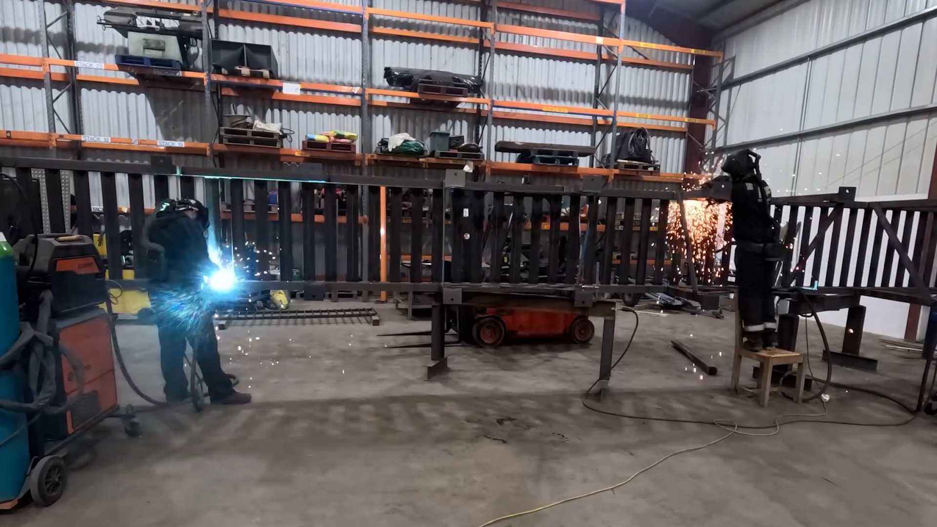 Team welding on heavy steel frame