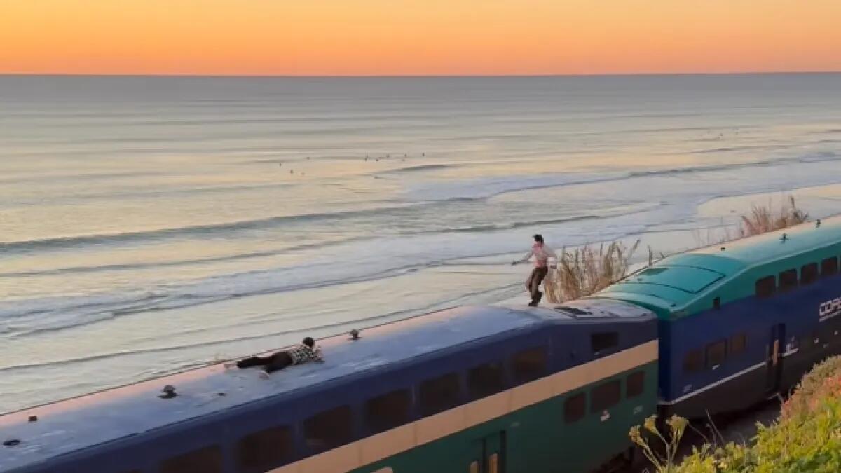 Daring duo ride on moving coaster train