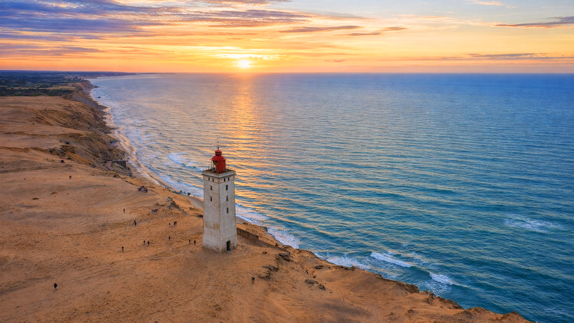 Golden sands and calm seas around a coastal lighthouse