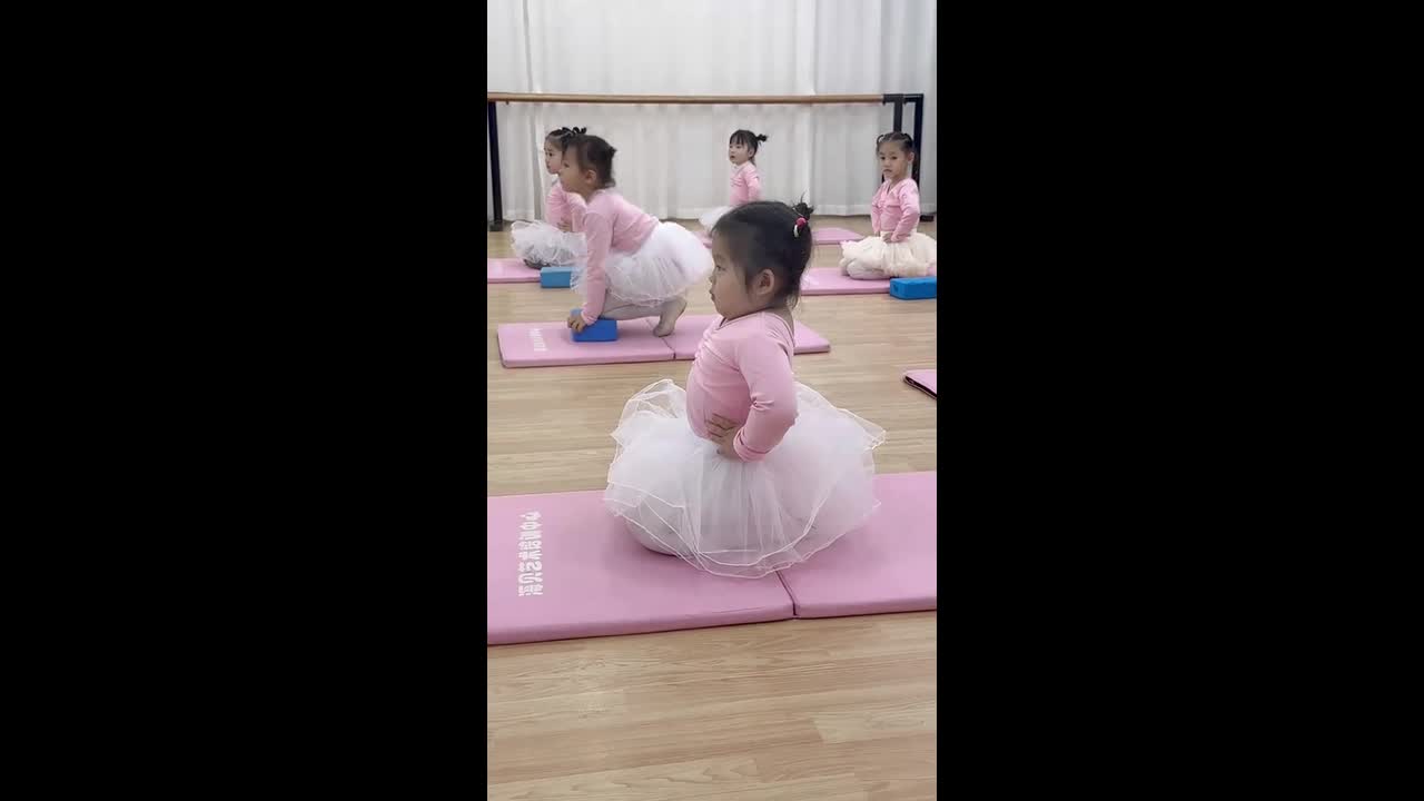 Young student holds posture during ballet training, Guangxi, China