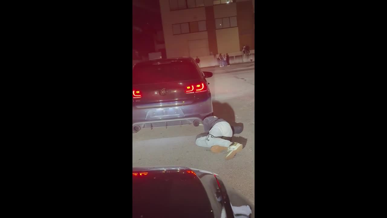 Man lights a cigarette using car exhaust flames in Porto, Portugal