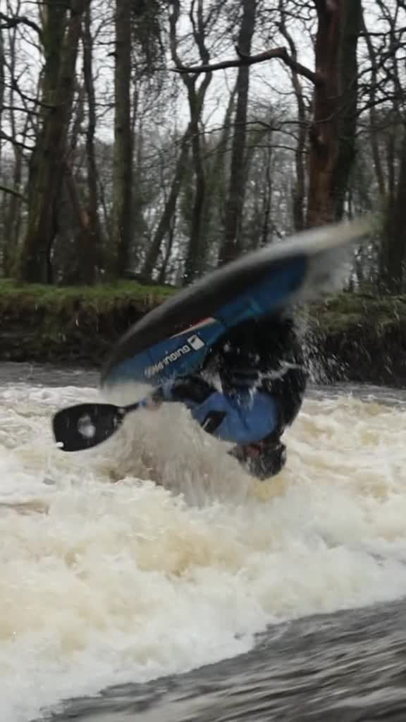 Slow motion freestyle kayaking flip on a winter river
