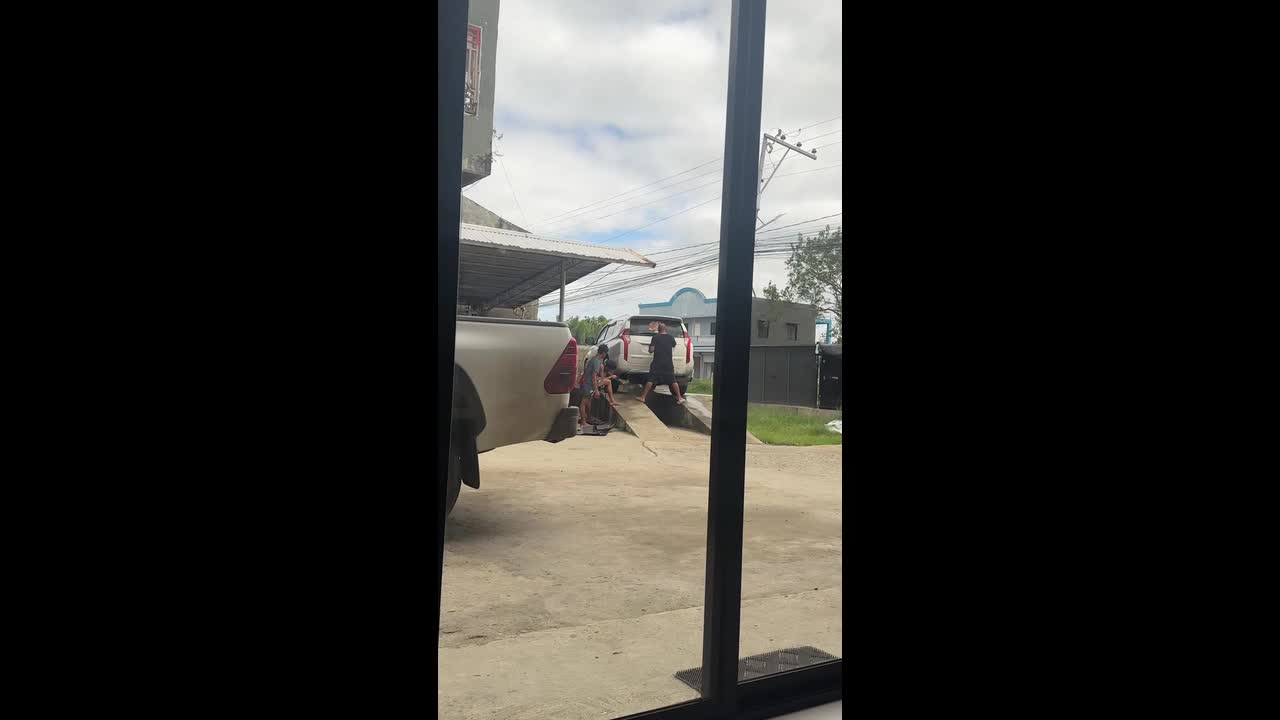 Stuffed toy being washed alongside a car in Roxas, Philippines