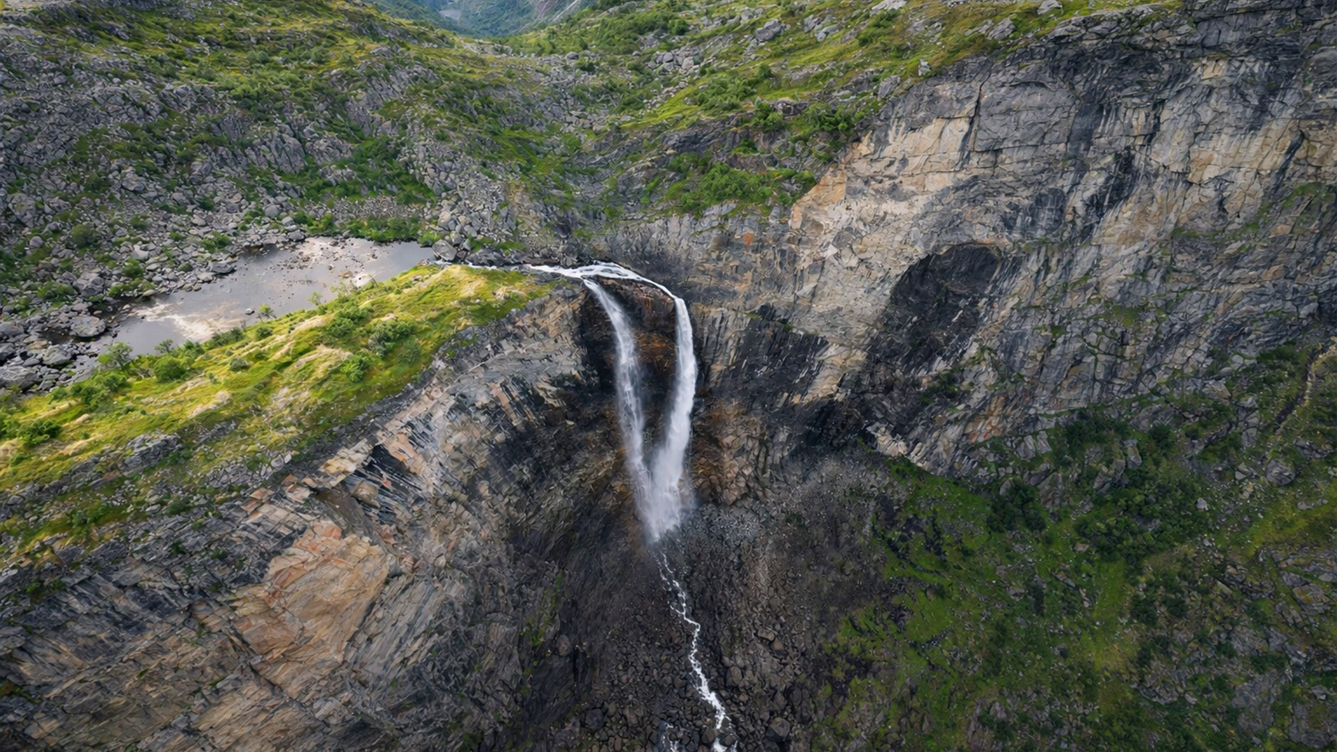 A dramatic waterfall against a towering rock face