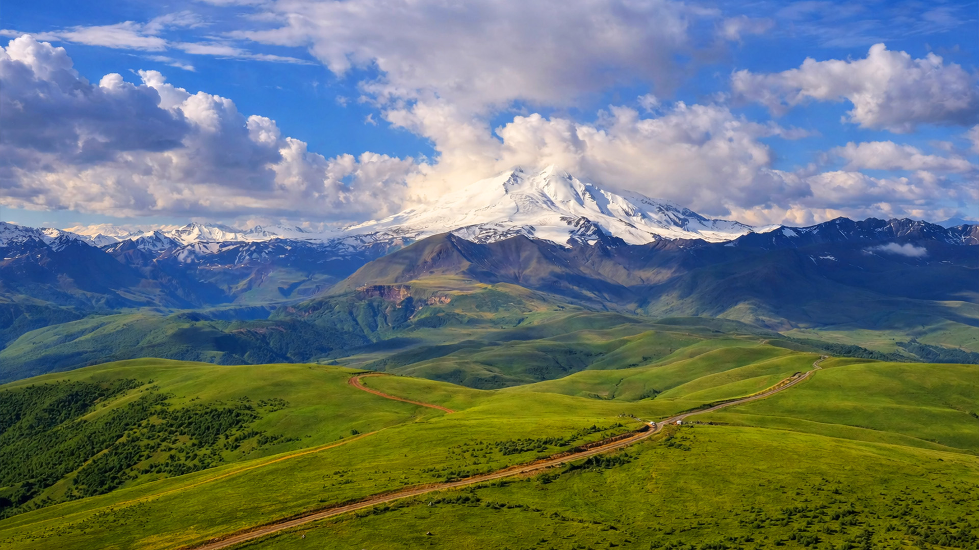 Rolling green hills leading toward Mount Elbrus