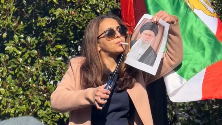 Iranian woman symbolically burns Khamenei photo